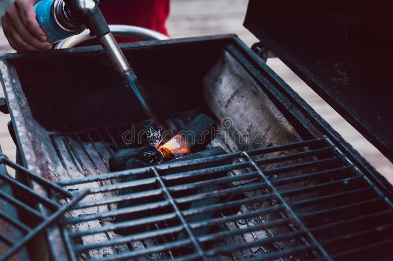 Man Using BBQ Lighter Torch To Start Fire for Charcoal. Stock Photo ...