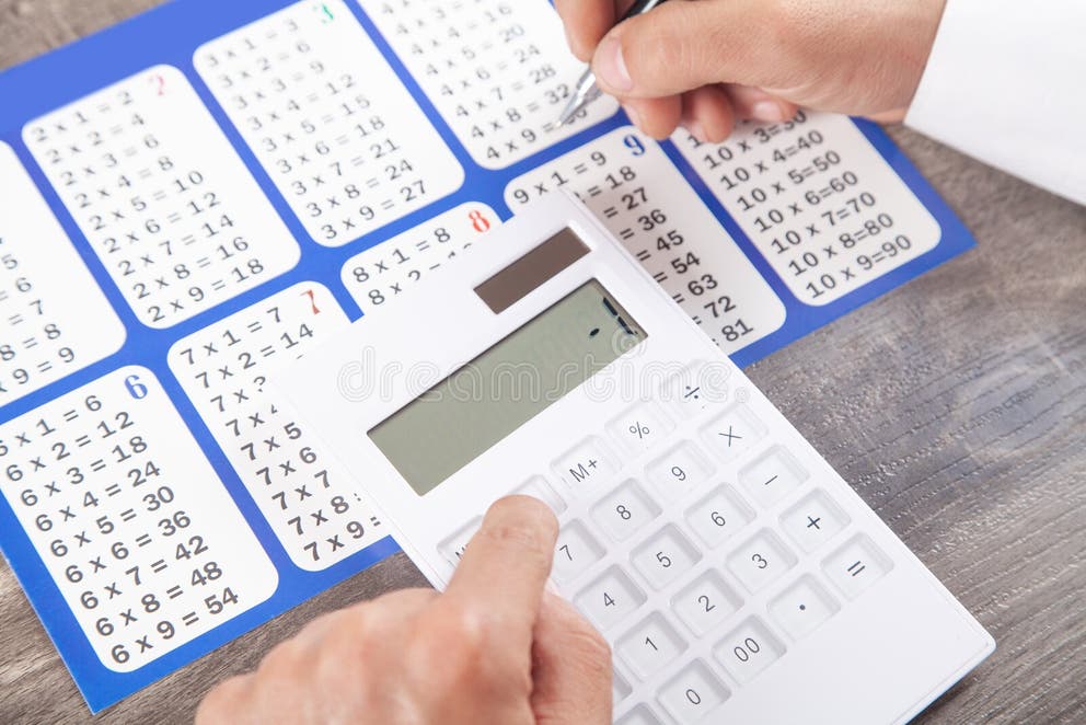 Man Using Calculator with a Multiplication Table Stock Photo - Image of ...