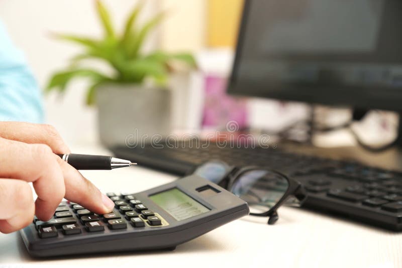 Man is Using Calculator with Pen in Hand. Picture of Computer, Keyboard ...