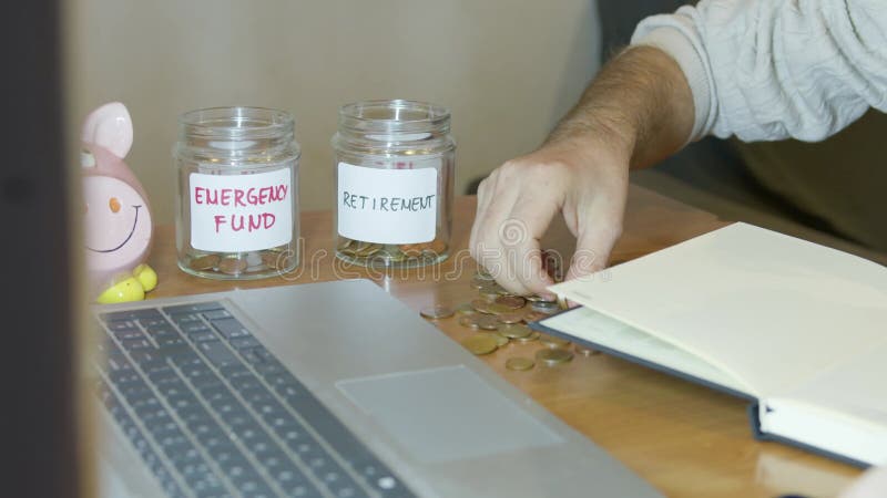 Man Using Calculator and Sorting Money into Jars for Retirement and ...