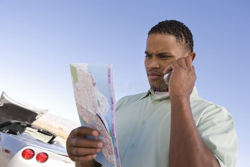 Man Using Cell Phone while Looking at Map Stock Photo - Image of sunny ...