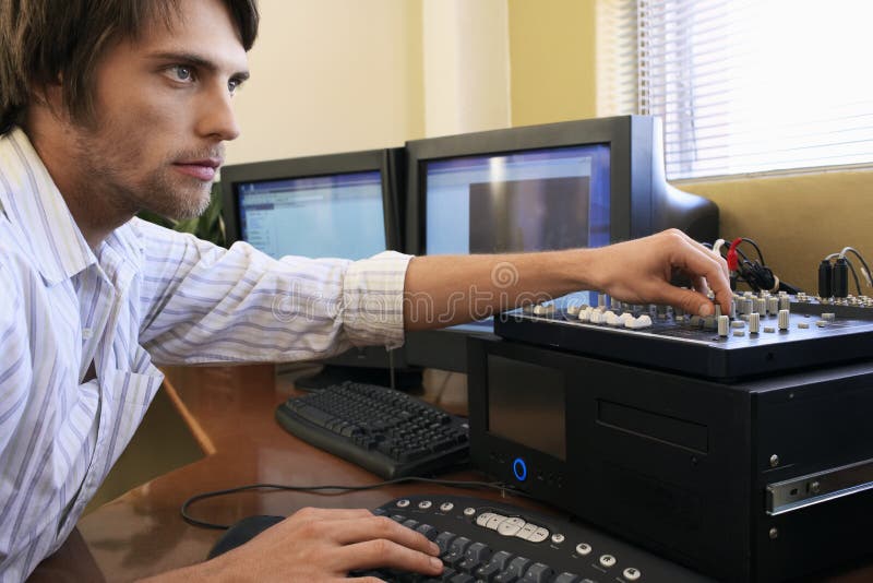 Man Using Computer Keyboard and Adjusting Knob on Mixer Stock Photo ...