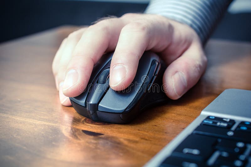 Man Using a Computer Mouse Next To a Laptop on a Table Stock Photo ...
