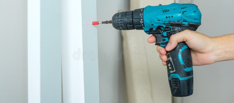 Man Using a Cordless Screwdriver Assembling Furniture at Home ...