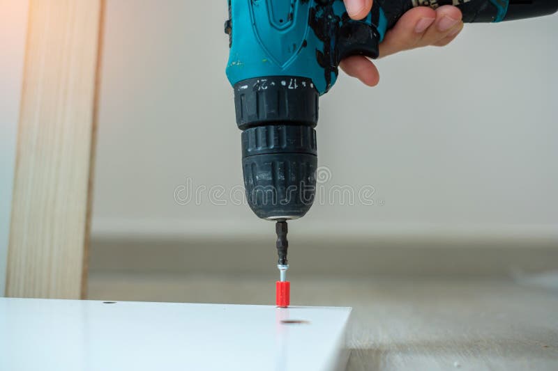 Man Using a Cordless Screwdriver Assembling Furniture at Home ...