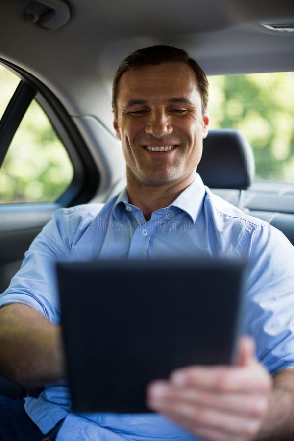Man Using Digital Tablet in Car Stock Photo - Image of four, shot: 90520102