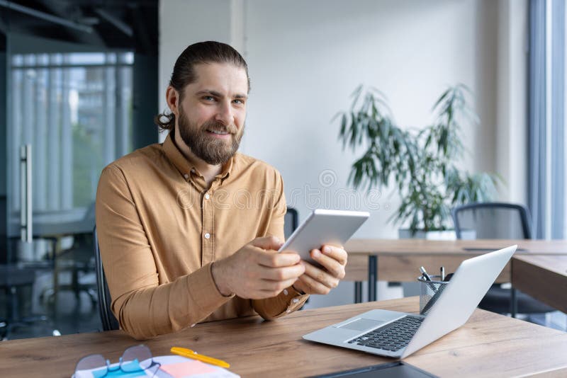 Man Using a Digital Tablet at His Workspace in Modern Office Setting ...