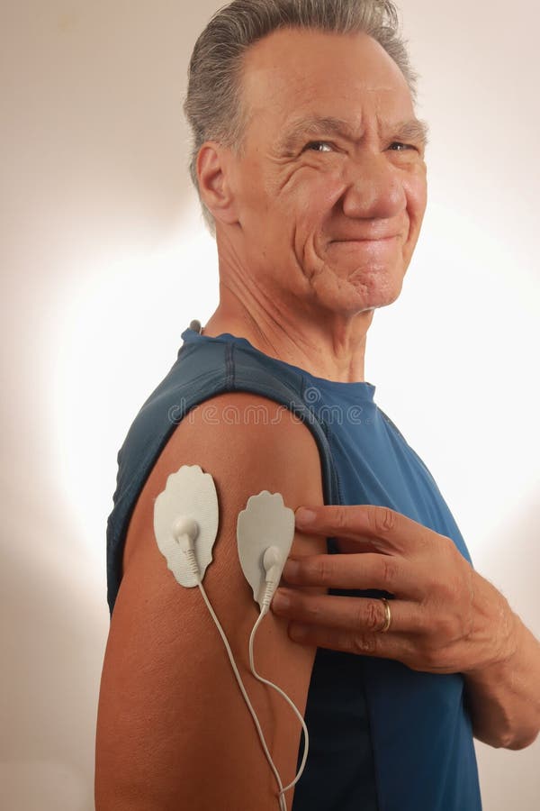 Man Using an Electro Therapy Massager or Tens Unit on His Deltods Stock ...