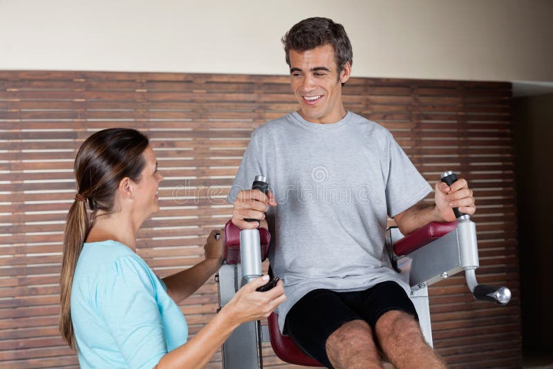 Man Using an Exercise Machine while Looking at Stock Image - Image of ...