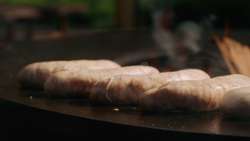 Man Using Forceps on Grill Outdoors. Man Turning Over Sausages on Grate ...