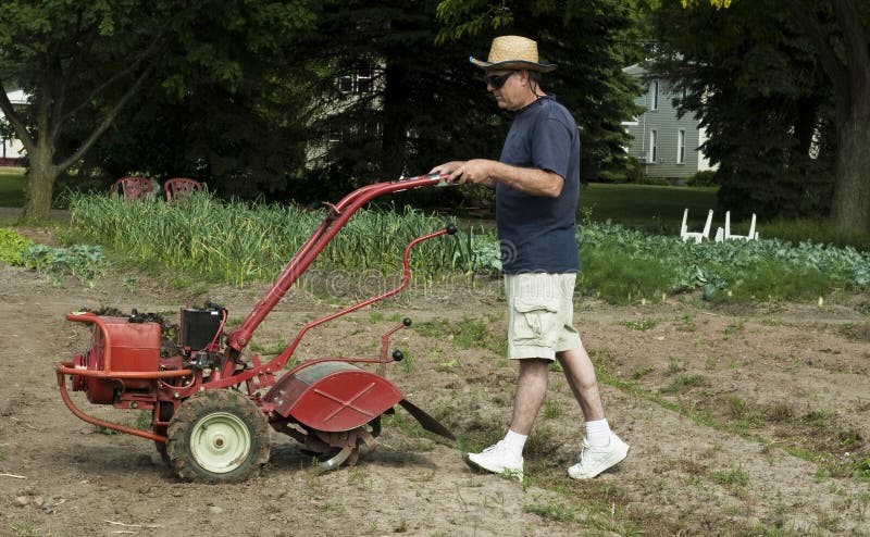 Man using a garden tiller stock photo. Image of tines - 19974862