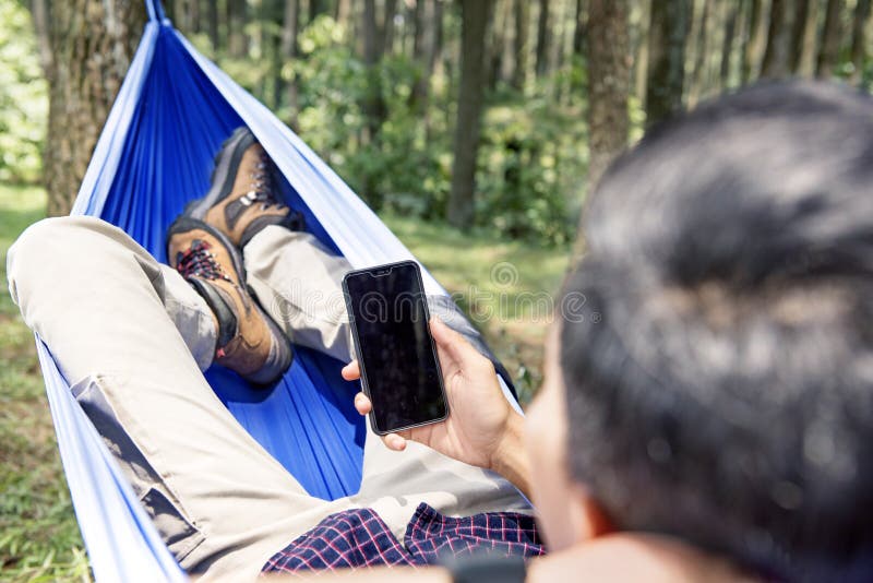 Man Using His Mobile Phone while Relaxing in Hammock Stock Image ...