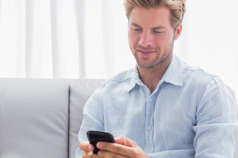 Man Using His Phone on a Couch Stock Image - Image of domicile, light ...