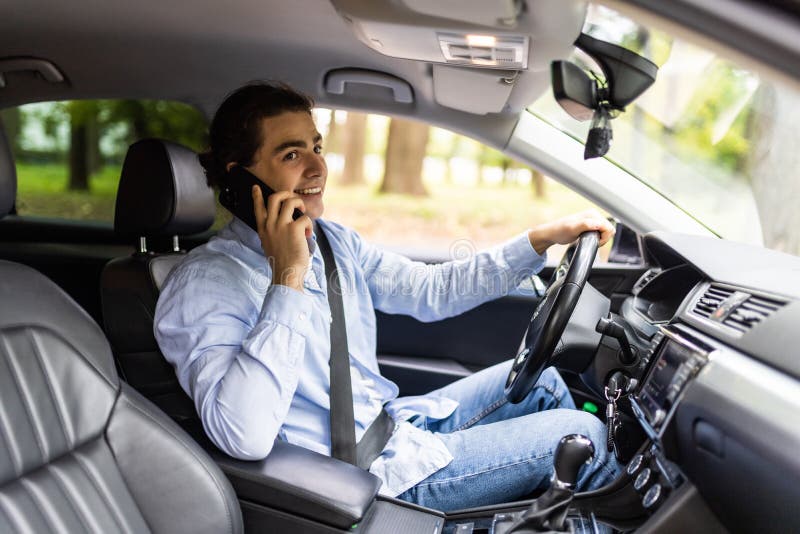 Young Man Using His Phone while Driving the Car Stock Photo - Image of ...