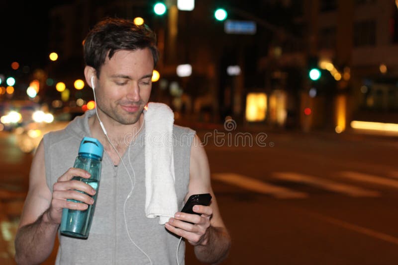 Young Athlete Looking at Cell Phone while Exercising in the City ...