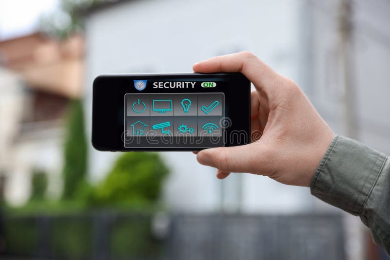 Man Using Home Security Application on Smartphone in Front of House ...