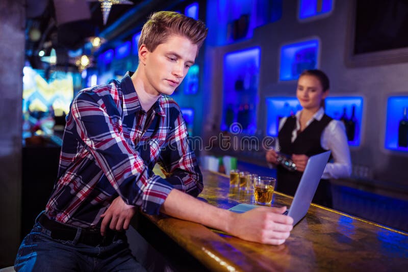 Man Using Laptop at Bar Counter with Bartender Working Stock Image ...