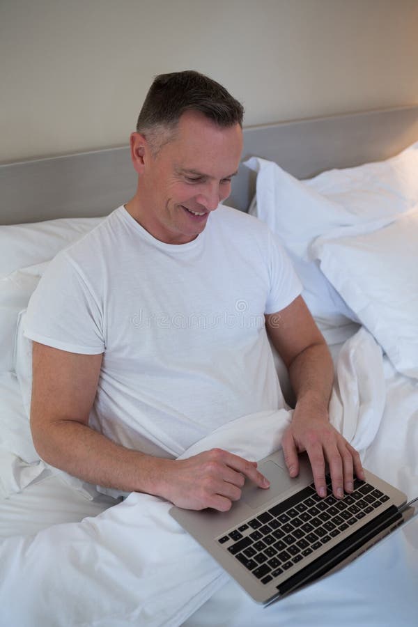 Man Using Laptop on Bed in Bedroom Stock Image - Image of concentration ...