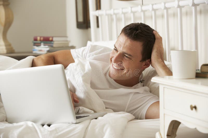 Man Using Laptop in Bed at Home Stock Photo - Image of laptop, twenties ...
