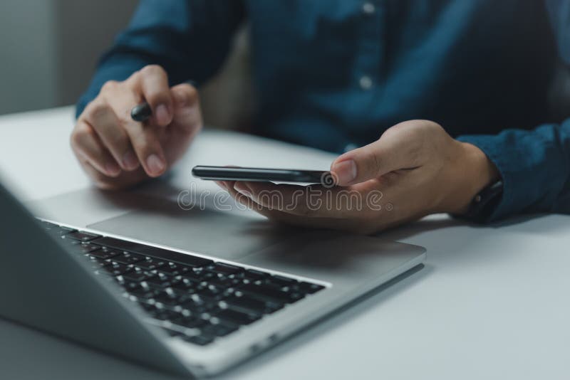 A Man is Using a Laptop and a Cell Phone Stock Image - Image of ...