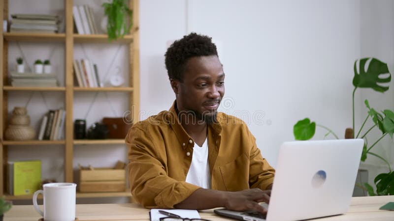 Man Using Laptop Computer and Having Fun, Sitting at Table in Home Room ...