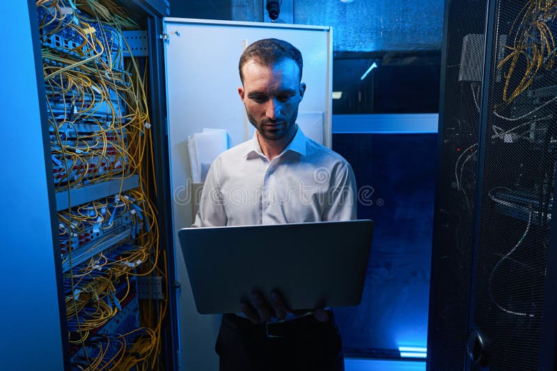 Man Using Laptop Near Open Server Cabinet Stock Image - Image of center ...
