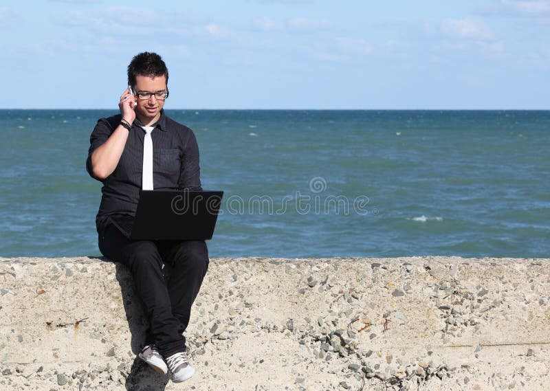 Man Using Laptop and Phone at Beach Stock Photo - Image of typing ...