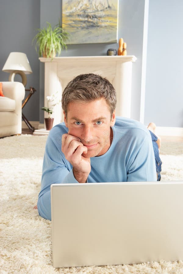 Man Using Laptop Relaxing Laying on Rug at Home Stock Image - Image of ...