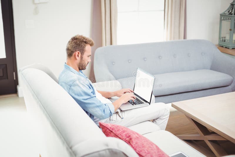 Man Using Laptop while Sitting on Sofa in Living Room Stock Image ...