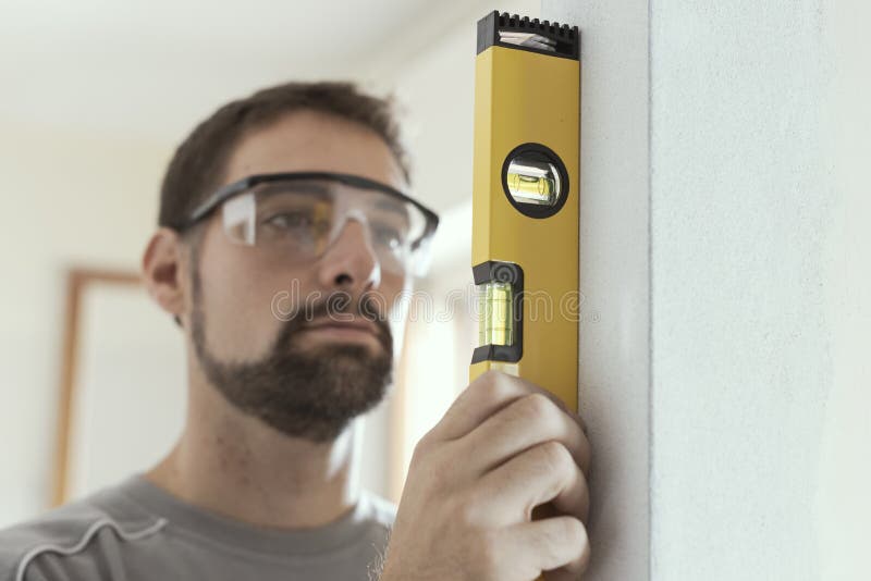 Man Using a Level To Plumb a Wall Stock Image - Image of level ...