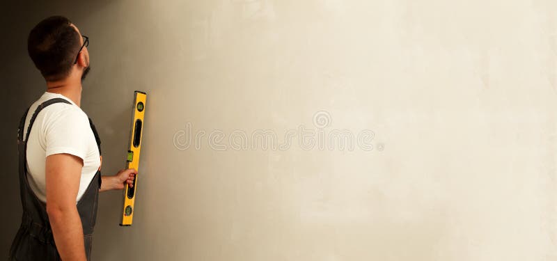 Man Using Level Tool on Wall, Ample Copy Space, Ideal for Banner Design ...