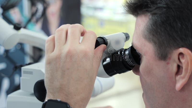Man Using Microscope for Close Examination. Close-up of a Man Looking ...