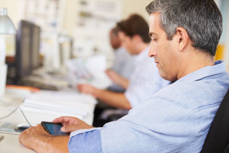 Man Using Mobile Phone at Desk in Busy Creative Office Stock Image ...