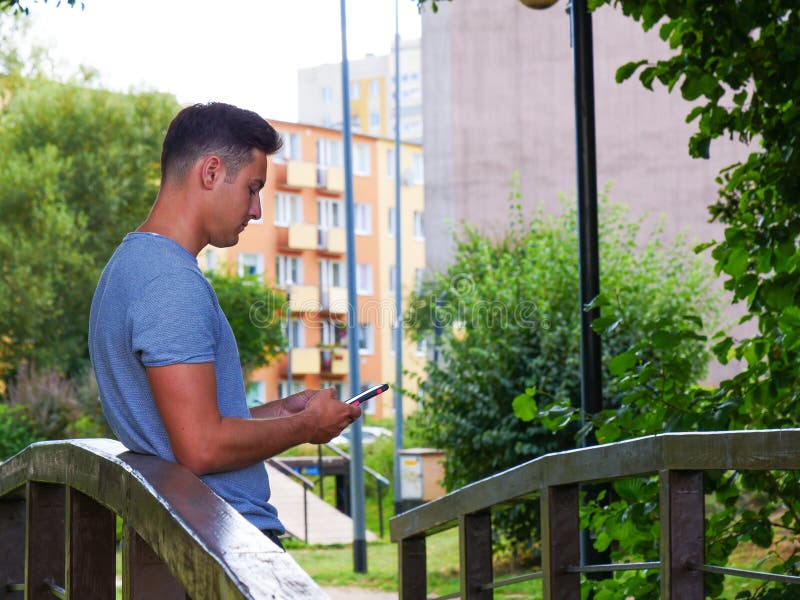 Man Using Mobile Phone in Park Stock Photo - Image of touch, texting ...