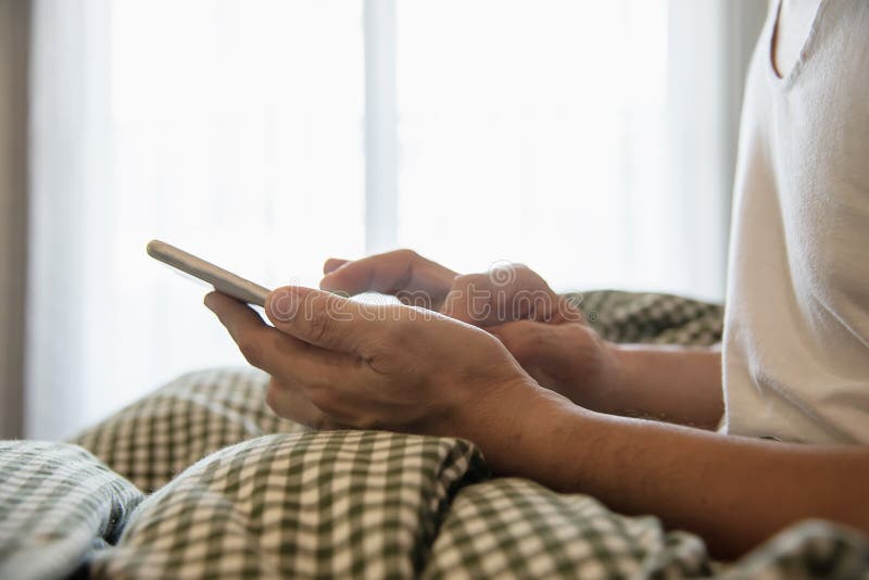 Man Using Mobile Phone while Wake Up on Bed in the Morning Stock Image ...