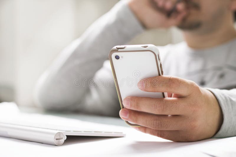 Man Using Mobile Phone while Working on Desktop Stock Photo - Image of ...