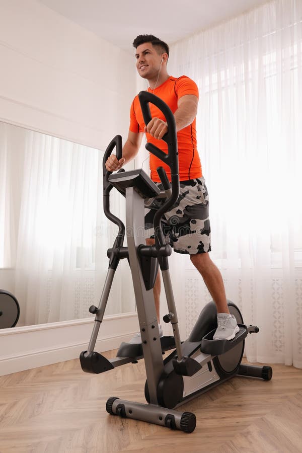Man Using Modern Elliptical Machine at Home Stock Image - Image of ...