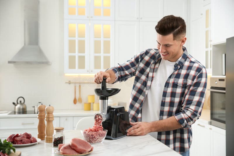 Man Using Meat Grinder in Kitchen Stock Image - Image of male ...