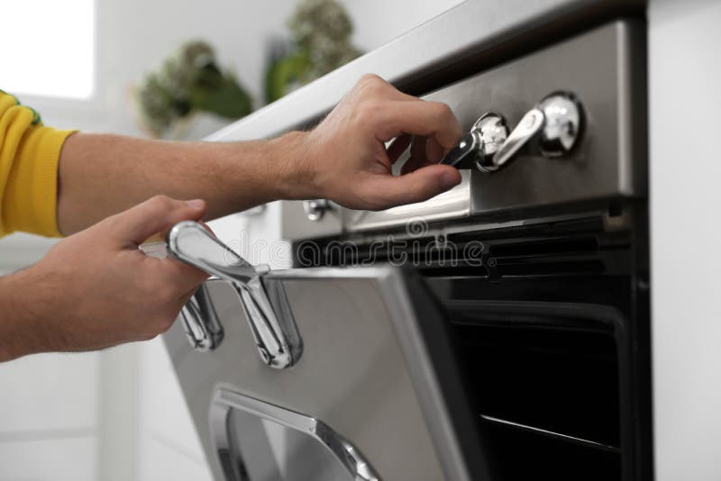 Man Using Modern Oven in Kitchen Stock Photo - Image of kitchen, hands ...
