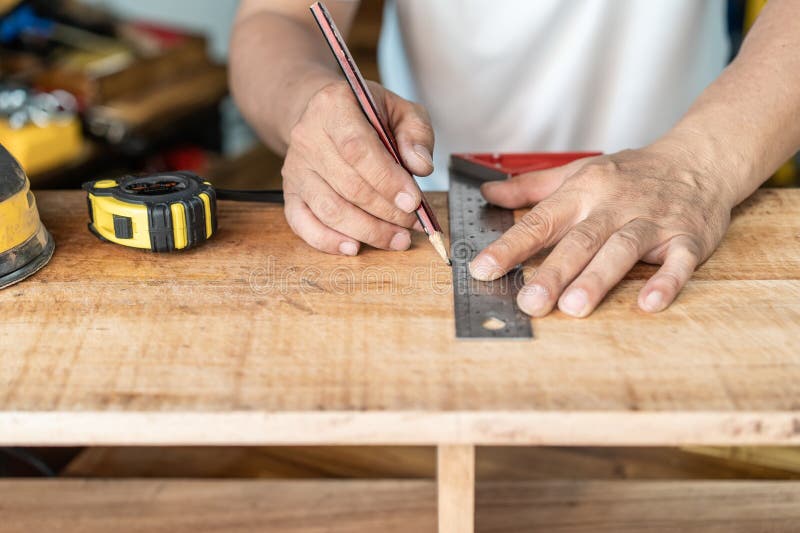 Man Using a Pencil Marking the Line on Wood Cabinet in the Workshop ...