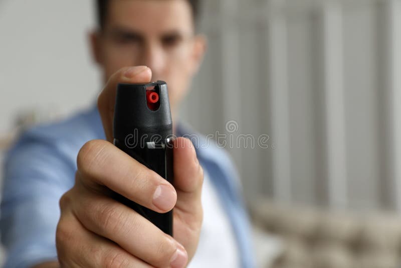 Man Using Pepper Spray at Home, Focus on Hand. Space for Text Stock ...