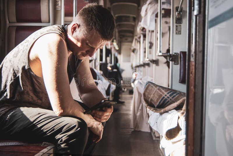 A Man Using a Phone in the Aisle of a Second-class Carriage of a High ...