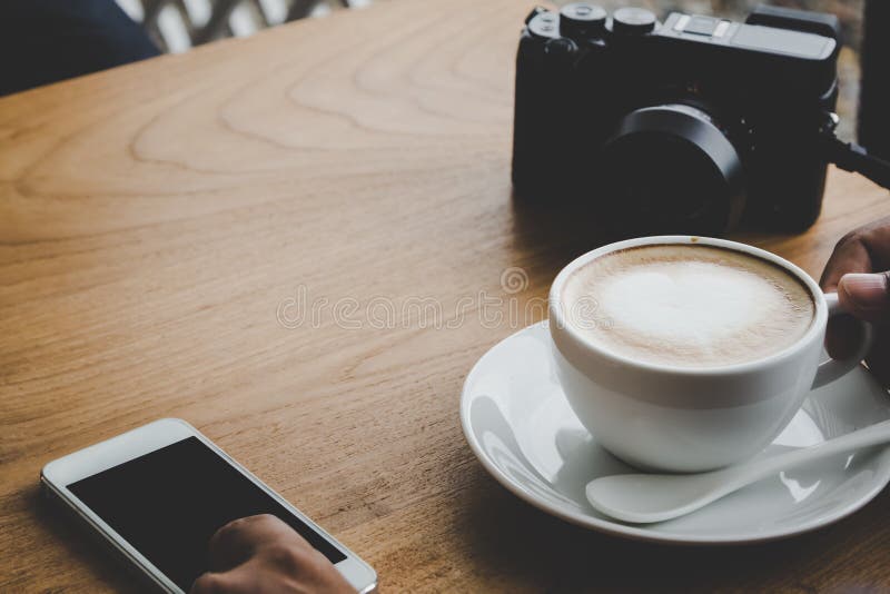 Man Using Phone with Coffee and Camera on Wood Table Stock Photo ...
