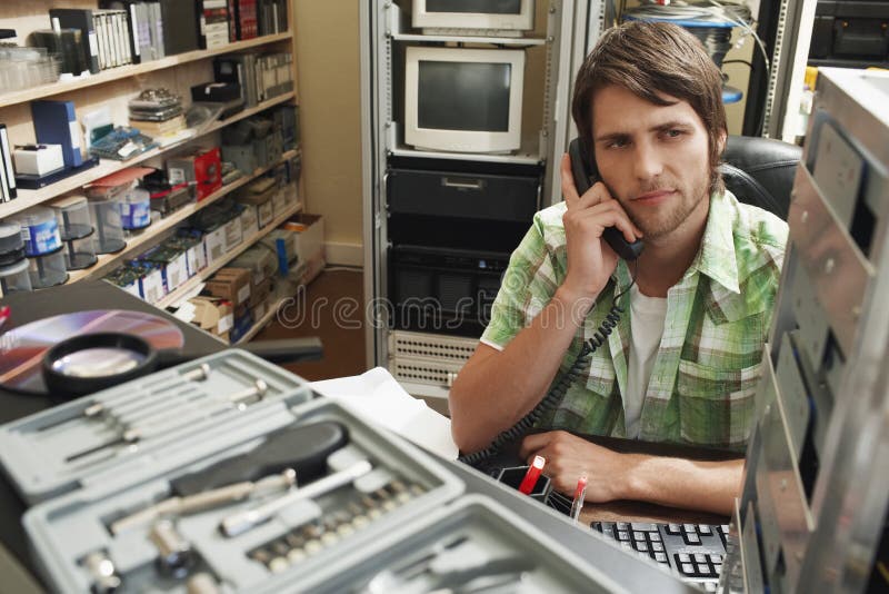 Man Using Phone Surrounded by Computer Equipment Stock Image - Image of ...