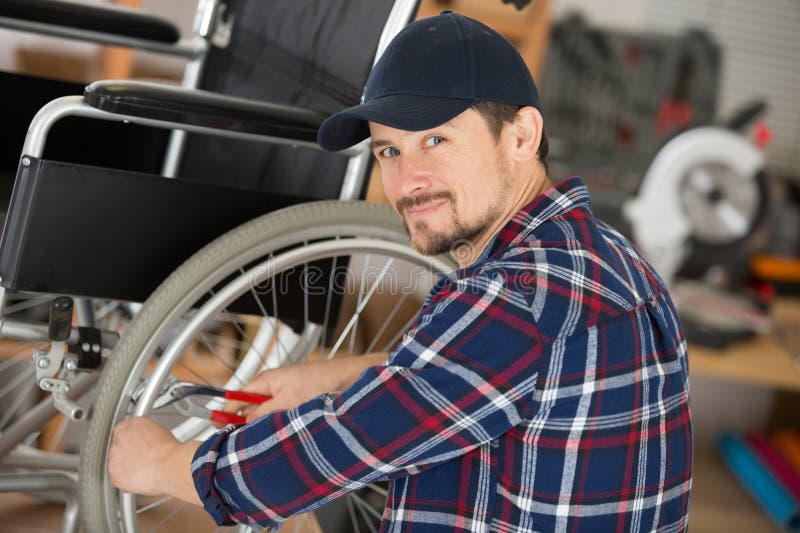 Man Using Pliers To Service Brakes on Wheelchair Stock Image - Image of ...