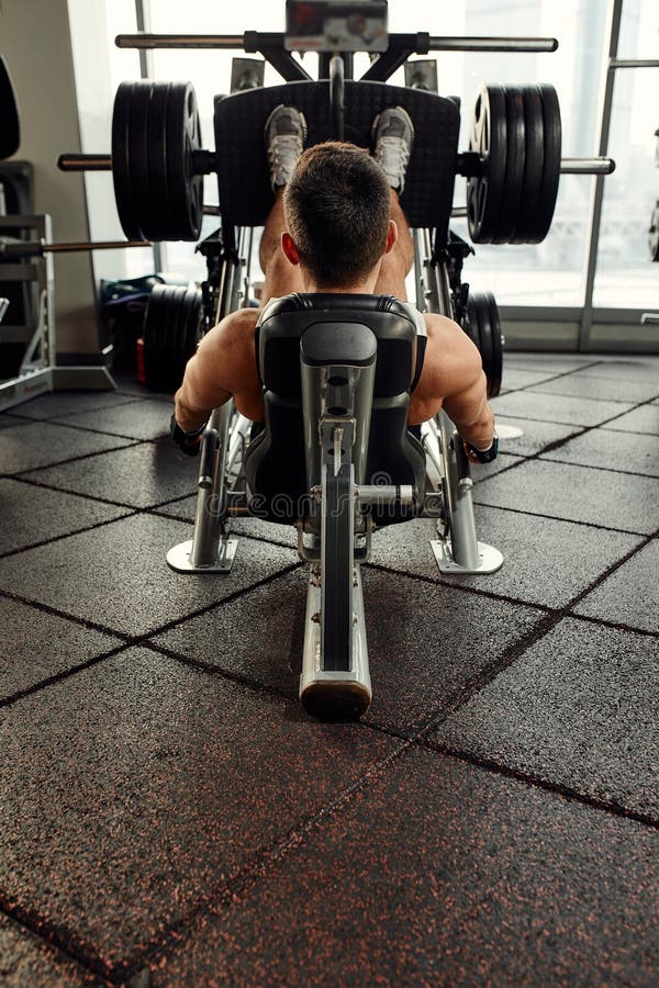 Man Using a Press Machine in a Fitness Club. Strong Man Doing an ...