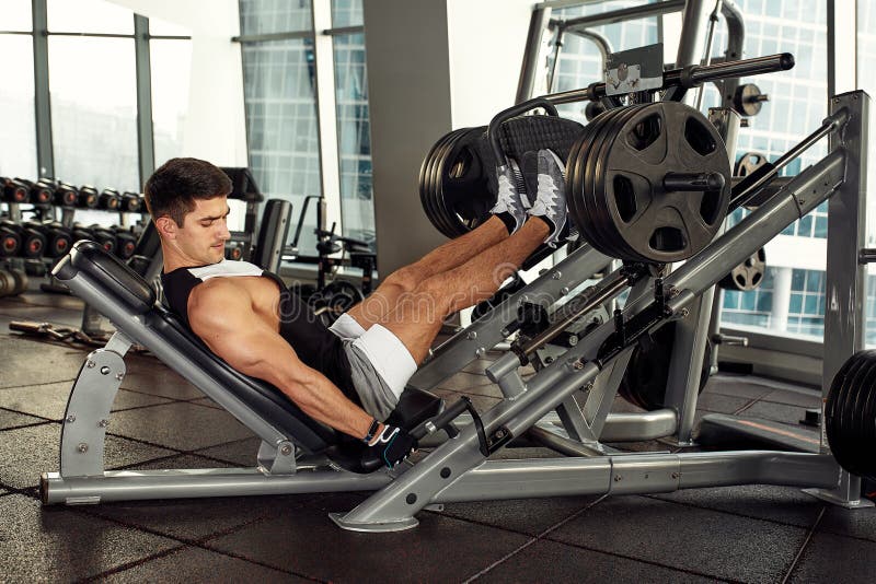 Man Using a Press Machine in a Fitness Club. Strong Man Doing an ...