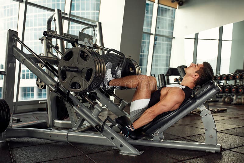 Man Using a Press Machine in a Fitness Club. Strong Man Doing an ...