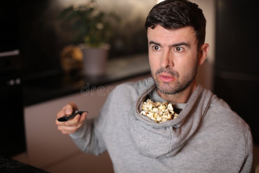 Man Using Remote Control while Enjoying His Popcorn Stock Photo - Image ...