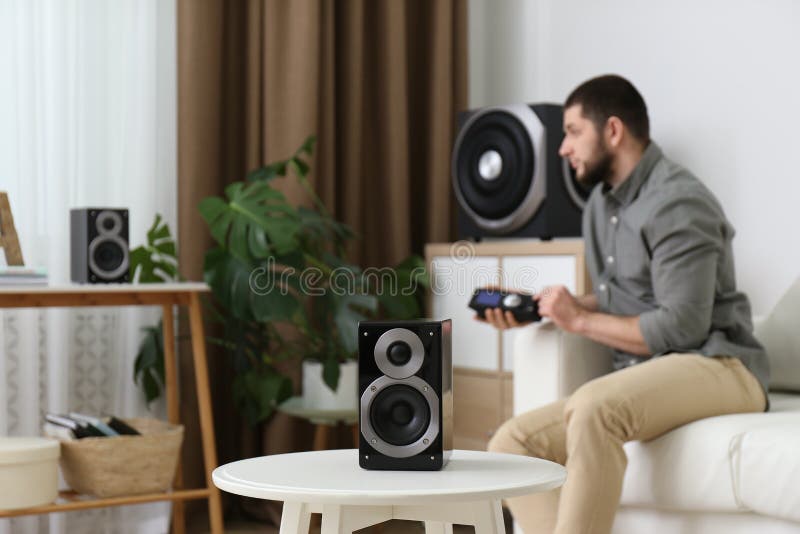 Man Using Remote To Control Modern Audio Speaker System in Bright Room ...